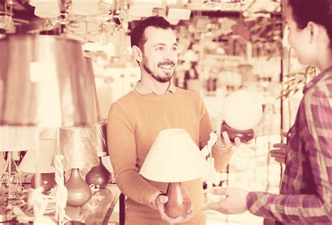 남자와 여자 집 인테리어에 대 한 세련 되 고 현대적인 램프를 선택 하는 라이터가 게에서 18 19세에 대한 스톡 사진 및 기타 이미지 18 19세 가격 고급