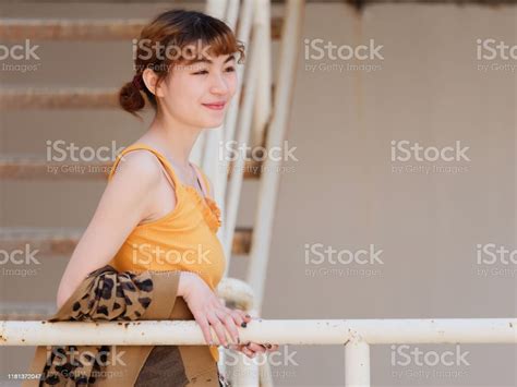 노란색 홀터 상단에 아름다운 젊은 여성의 초상화는 웃고 난간에 손으로 걷고 측면보기 친절한 찾고 얼굴 20 29세에 대한 스톡 사진 및 기타 이미지 Istock