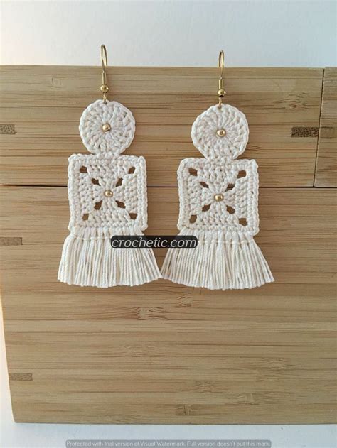 Crochet Earrings With Tassels On Wooden Background
