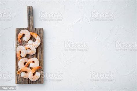나무 도마에 흰색 배경에 상단 보기 평면 누워 카피 스페이스와 텍스트를위한 공간 전체 신선한 껍질을 벗긴 요리 새우 새우