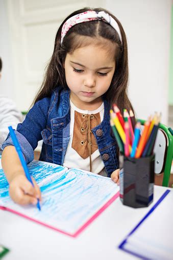 Gadis Kecil Menggambar Dengan Pensil Berwarna Dalam Buku Foto Stok