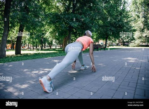 Pretty Young Sporty Woman In Park In Sportswear Warming Up Exercising