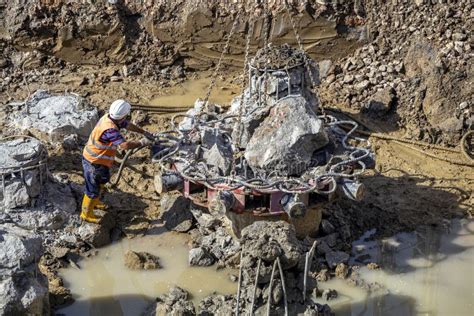 Construction Worker Using Hydraulic Concrete Pile Cutter And Breaking Concrete Editorial