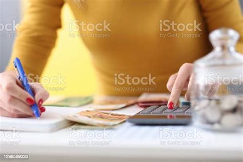 Tangan Wanita Memegang Pena Dan Menghitung Uang Kertas Pada Kalkulator