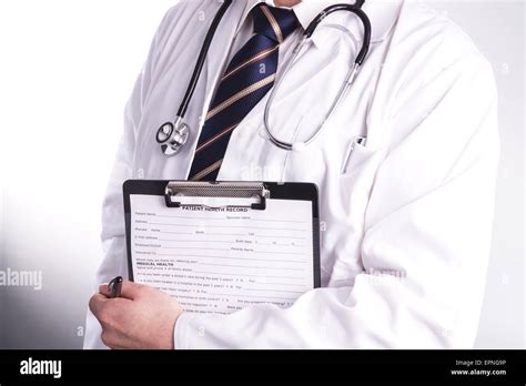 Male Doctor Fills Patient Registration Form Prior To Admission And