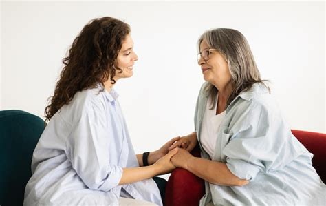 Premium Photo Smiling Elderly Woman Hugging Millennial Lady Talking