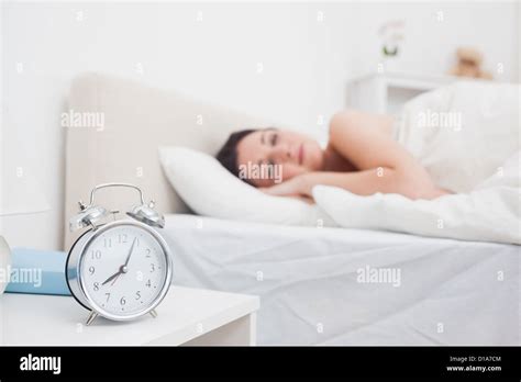 Femme de dormir dans le lit avec l accent sur réveil Photo Stock Alamy
