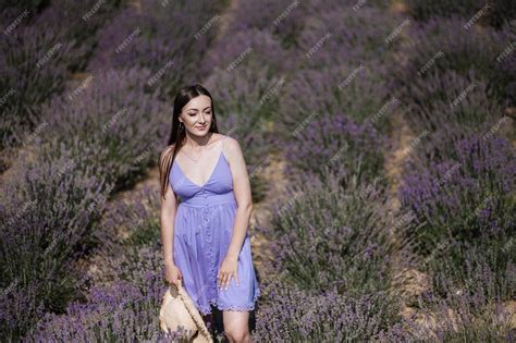 Una Chica Con Un Vestido Morado Y Un Sombrero Grande Posa En Un Campo