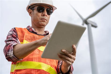 Safery 헬멧 작업을 가진 수석 전기 엔지니어 윈드 밀 또는 태블릿 또는 클립 보드와 풍력 터빈 전원 발전기 역 청정 에너지 개념 개발에 대한 스톡 사진 및 기타 이미지
