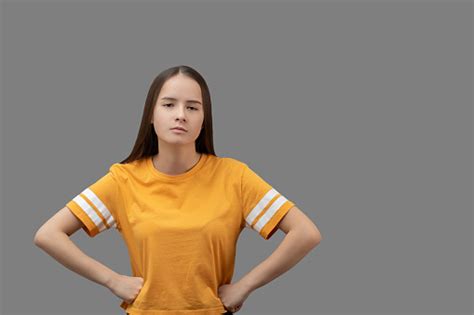 긴 갈색 머리를 가진 심각한 젊은 백인 소녀 회색 배경에 고립 된 벨트에 손을 잡고 십대에 대한 스톡 사진 및 기타 이미지 십대 자신감 갈색 머리 Istock