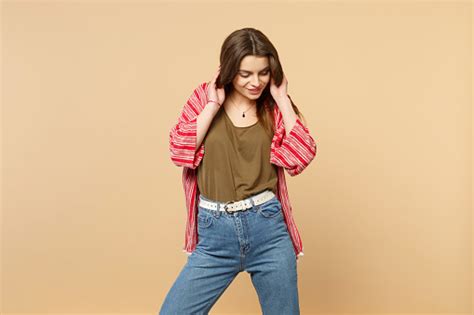 캐주얼에 예쁜 부드러운 젊은 여자의 초상화 스튜디오에서 파스텔 베이 지 배경에 고립 된 아래로 보이는 머리에 손을 퍼 팅