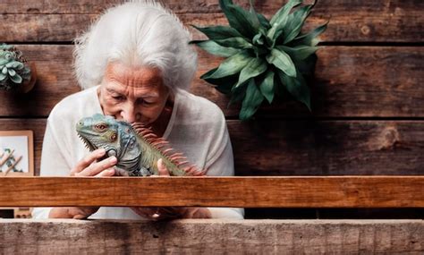 Premium Photo An Old Woman Holds A Lizard And Kisses It