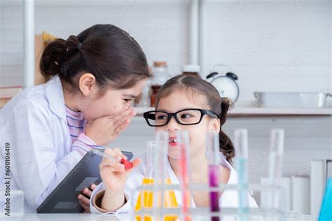 Foto De Adorable Asian Girls Wearing Lab Coat Whispering Secrets And