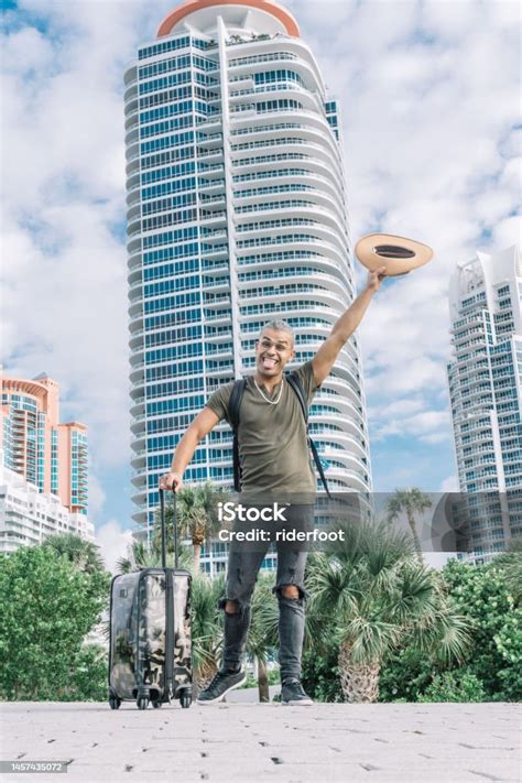행복한 작별 인사를하고 얼굴을 만들기 위해 모자를 흔드는 남자 멋진 마천루 배경 25 29세에 대한 스톡 사진 및 기타 이미지 25 29세 가방 관광 Istock