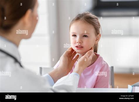 Médico Que Revisa Las Amígdalas De La Paciente En La Clínica Fotografía