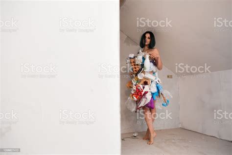 플라스틱과 골판지로 만든 쓰레기 드레스를 입고 웃는 여성 에코 파이터의 초상화는 오염 인식 개념에서 환경 청소 자연을 확산하는