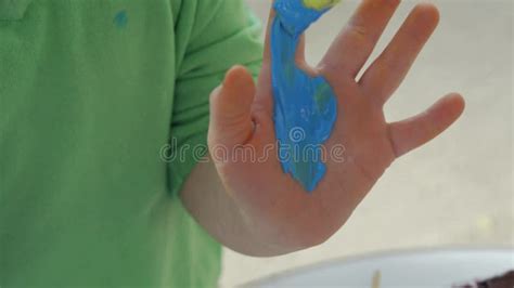 Pintura Con Pintura Amarilla Y Azul En Las Manos Del Niño Metrajes