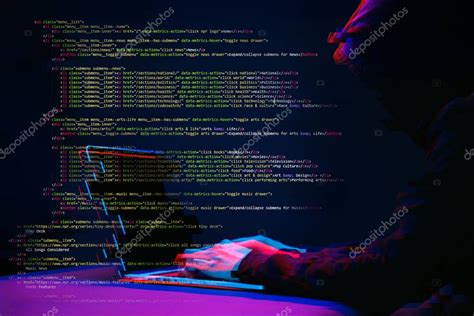 Hacker que trabaja con el ordenador portátil en la habitación oscura