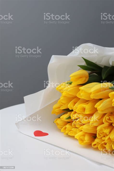 흰색 패키지에 노란색 튤립의 아름다운 큰 꽃다발과 흰색 테이블에 빨간색 심장 색종이 닫혀 축 축제 배경 복사 공간을 복사합니다 0명에 대한 스톡 사진 및 기타 이미지