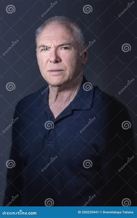 Portrait Of A Handsome Elderly Man In A Dark Blue Polo On A Dark