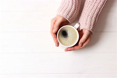 나무 테이블에 여성의 손에 거품과 커피 한 잔 맨 위 보기입니다 라떼아트에 대한 스톡 사진 및 기타 이미지 라떼아트 오래된