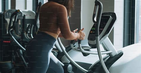 Young Brunette Woman Training For Cardio Equipment At Fitness Club Gym