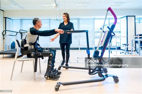 기계식 외골격 물리 치료 보조원이 로봇 골격으로 장애인을 들어 올려 일어납니다 미래형 재활 현대식 병원의 물리치료 건강관리와 의술에 대한 스톡 사진 및 기타 이미지 Istock