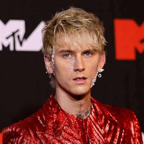 Machine Gun Kelly Debuts Fangs After Blacking Out His Tattoos