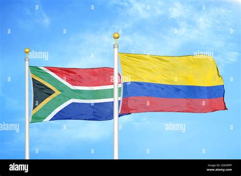 South Africa And Colombia Two Flags On Flagpoles And Blue Sky Stock