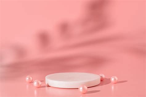 분홍색 배경에 분홍색 진주가 있는 흰색 대리석 연단과 열대 식물의 그림자 제품 화장품 프리젠 테이션연단 창조적 인 조롱 미용