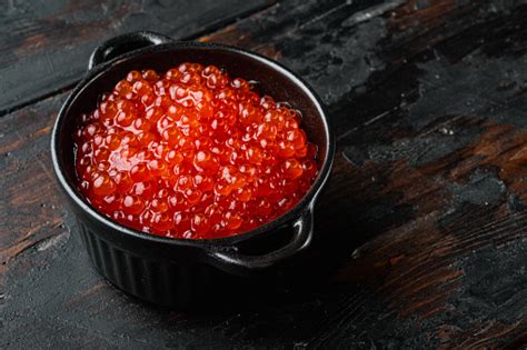맛있는 빨간 캐비어가있는 검은 그릇 오래된 어두운 나무 테이블 배경에 텍스트 복사 공간이 있습니다 0명에 대한 스톡 사진 및