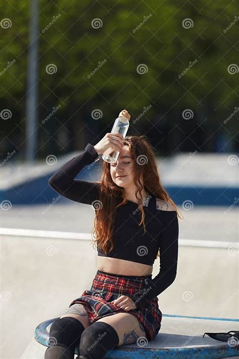 Exhausted Skater Female Sitting In A Concrete Pool With A Glass Bottle