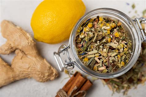 마른 찻잎이 든 항아리 레몬과 생강을 곁들인 해독 및 면역 차 민트 레몬 밤 카모마일 라벤더 로즈힙 흰색 시멘트 배경에 구성입니다 0명에 대한 스톡 사진 및 기타 이미지