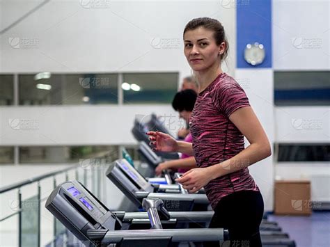 年轻的模特女孩在健身房的镜子前做运动