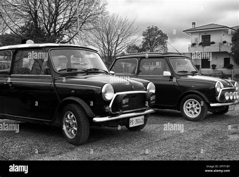 A Grayscale Shot Of Two Mini Coopers Parked On The Street In Italy Stock Photo Alamy