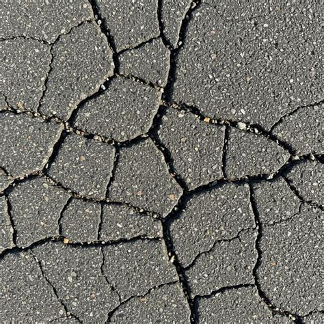 Cracked Asphalt Surface With Irregular Jagged Patterns The Rough Texture Contains Stock