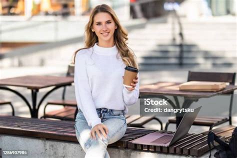 나무 벤치에 앉아있는 동안 종이 커피 컵을 들고 젊은 여자 노트북에 대한 스톡 사진 및 기타 이미지 노트북 마실 것 백인종 Istock