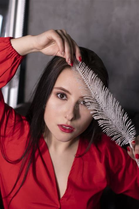 Portrait Of Attractive Brunette Woman In Red Blouse With A Big White