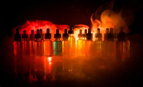 Vape 개념입니다 어두운 배경에 연기 구름과 Vape 액체 병 조명 효과 배경 또는 전자 담배 광고로 유용 합니다 0명에 대한