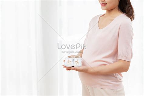 아이의 신발을 들고 임신 한 여자 사진 무료 다운로드 Lovepik