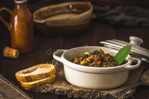 Bowl Of Lentil Stew Toasted Bread And Bay Leaf On Rustic Wooden Table