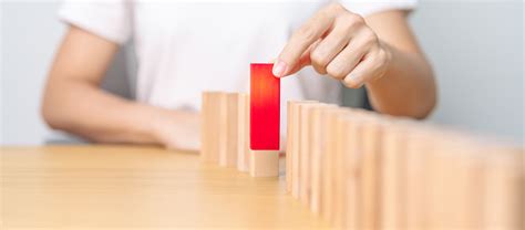 테이블에 빨간 도미노 나무 블록을 손으로 놓거나 당깁니다 사업 계획 위험 관리 솔루션 리더 전략 다른 고용 인적 자원 및 고유 개념 개념에 대한 스톡 사진 및 기타 이미지