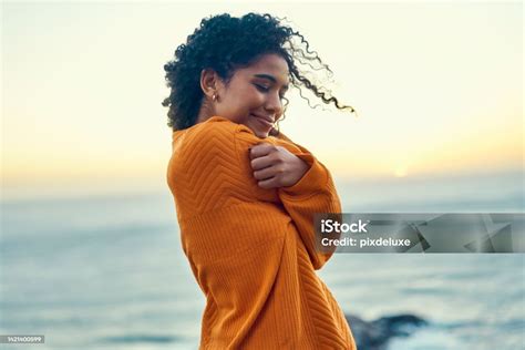 행복한 흑인 여성은 일출 자기 사랑과 평화의 해변에서 자신을 포옹합니다 지구와 자연과 접촉하는 젊은 아프리카 계 미국인은 자유와 내면의 평화를 즐기며 미소 짓고 사랑하는