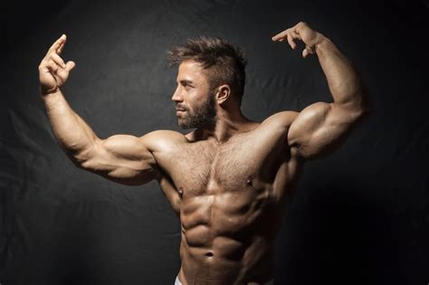 Premium Photo Portrait Of Muscular Build Man Against Black Background