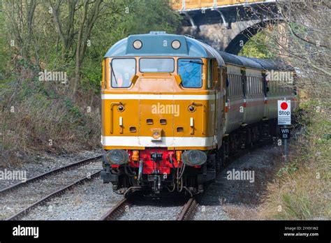 Preserved Class 31 Diesel Number 31190 Hauling A Train Under An Arched Bridge In Orange And Preserved Class 31 Diesel Number 31190 Hauling A Train Under An Arched Bridge In Orange And