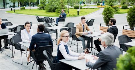 정장을 입은 소규모 직원들이 야외 여름 카페의 테이블 옆에 앉아 휴식을 취하고 이야기를 나눕니다 사진 Unsplash의 얘기 이미지