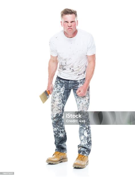 2029세 성인 잘생긴 자백 의 전면 남성 화가 집 화가 앞에 서 있는 T 셔츠 셔츠 청바지를 입고 페인트 브러시를 들고 있는 전체 길이 1인 정면 20 29세에 대한 스톡