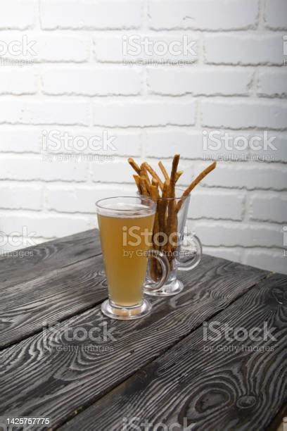 맥주 잔에 맥주를위한 얇은 소시지 그 옆에는 밀 맥주 한 잔이 있습니다 소나무 판의 배경 클로즈업 0명에 대한 스톡 사진 및