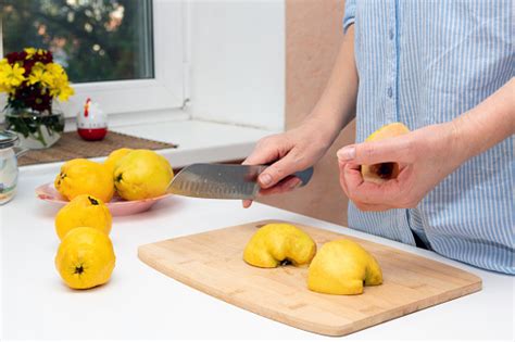 칼을 가진 여자의 손은 잘 익은 퀸스를 반으로 자른다 작물의 처리 선택적 초점 모과에 대한 스톡 사진 및 기타 이미지 모과
