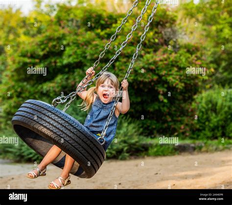 A Young Girl Makes A Silly Face As She Swings On A Tire Swing Edmonton